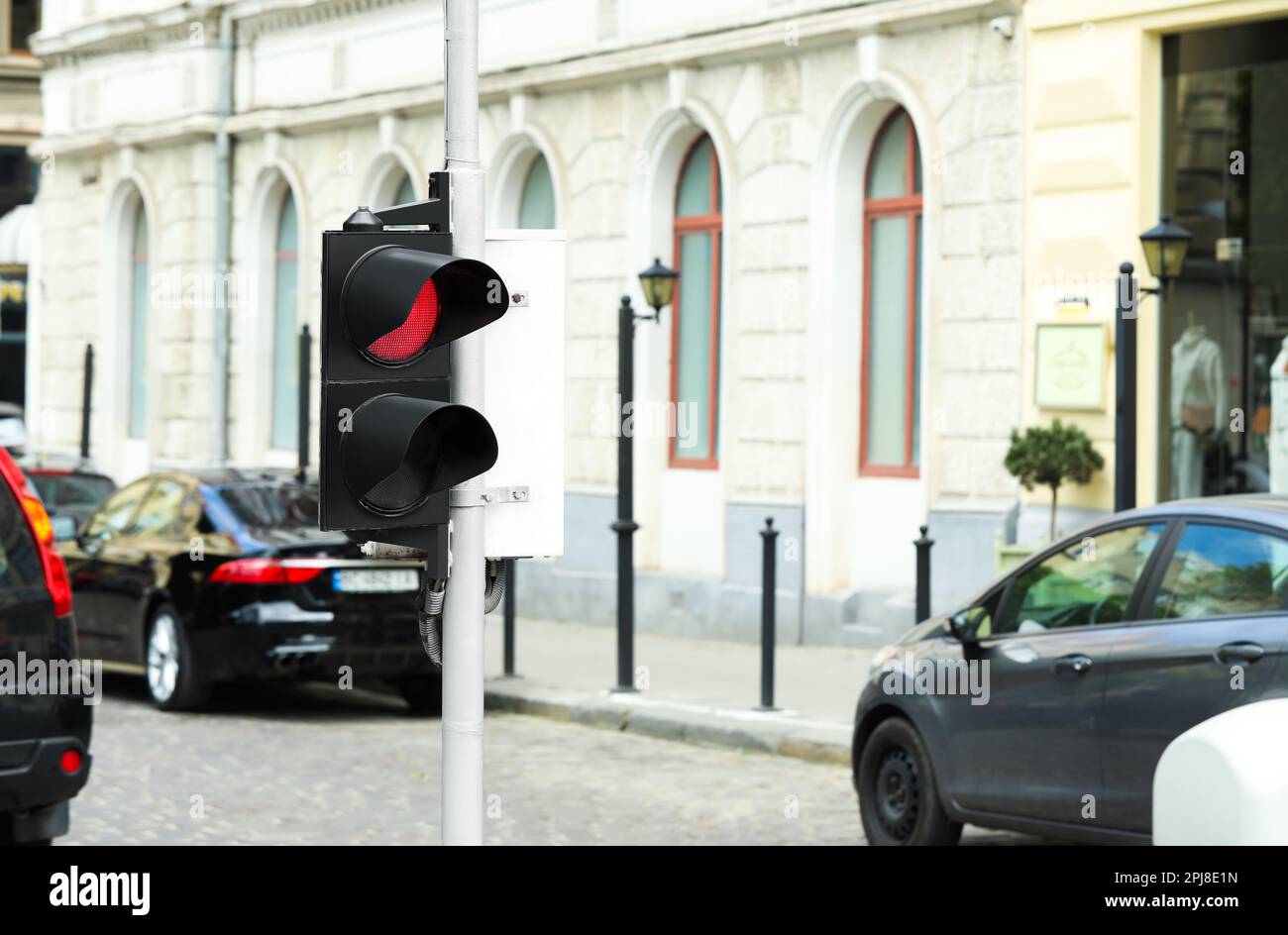 Post with traffic light on city street Stock Photo - Alamy