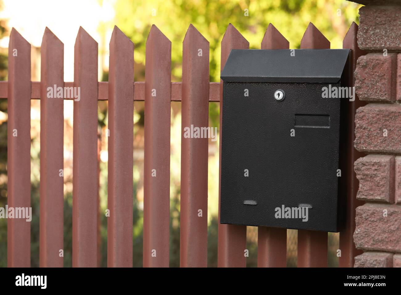 Black metal letter box on fence outdoors Stock Photo - Alamy