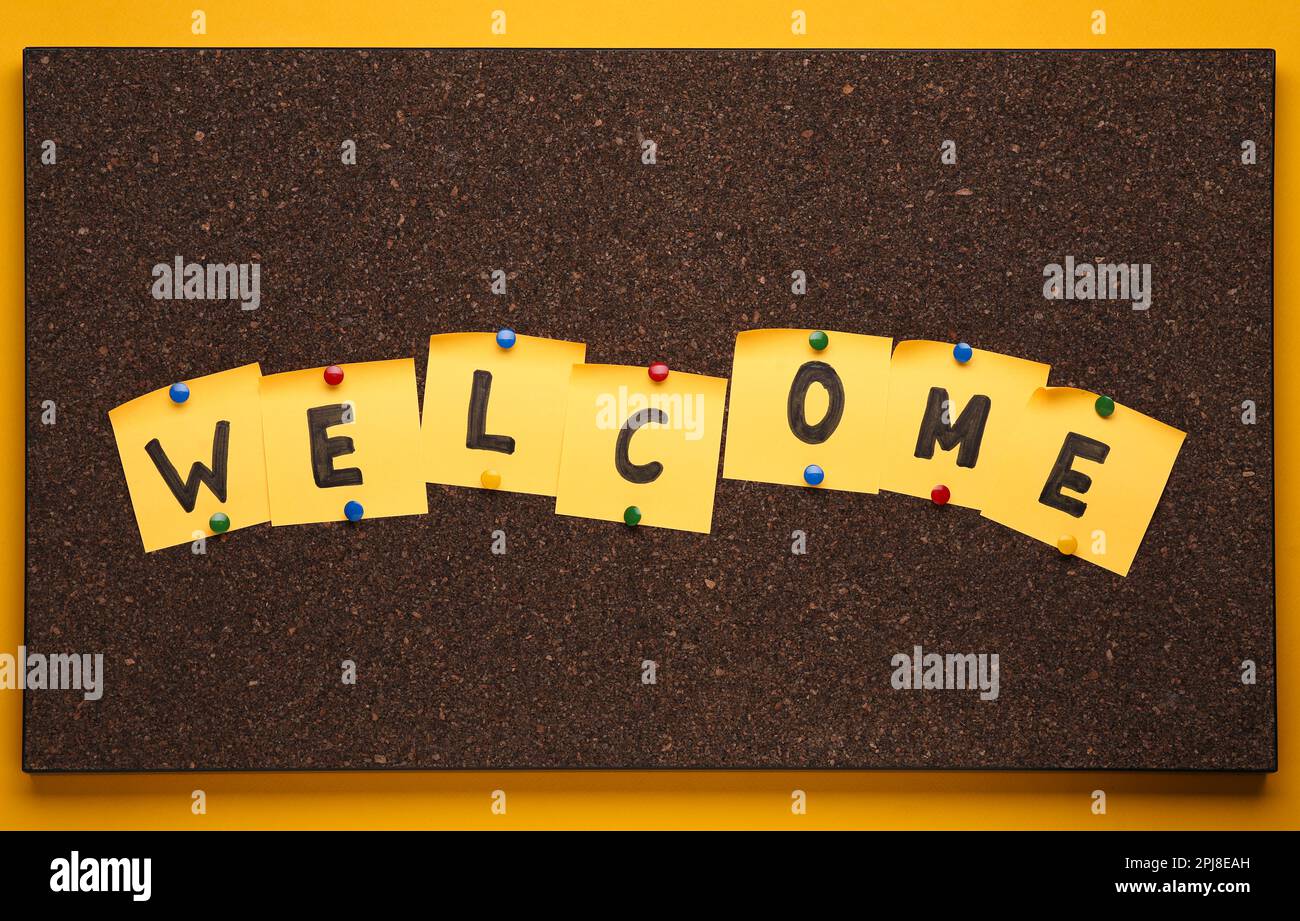 Corkboard with word Welcome made of paper notes on yellow background ...