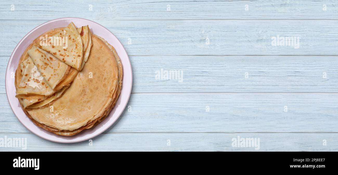 Delicious crepes on white wooden table, top view with space for text ...