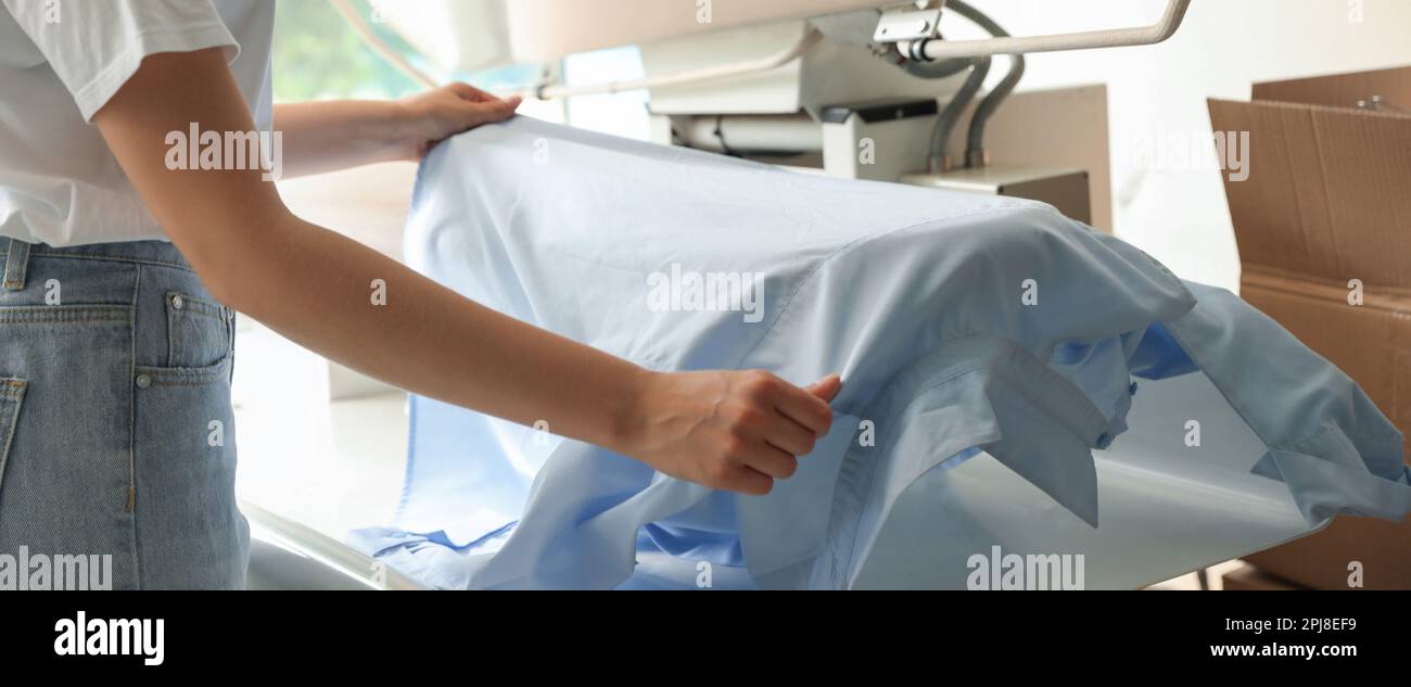 Closeup view of female worker using ironing press, banner design. Dry ...