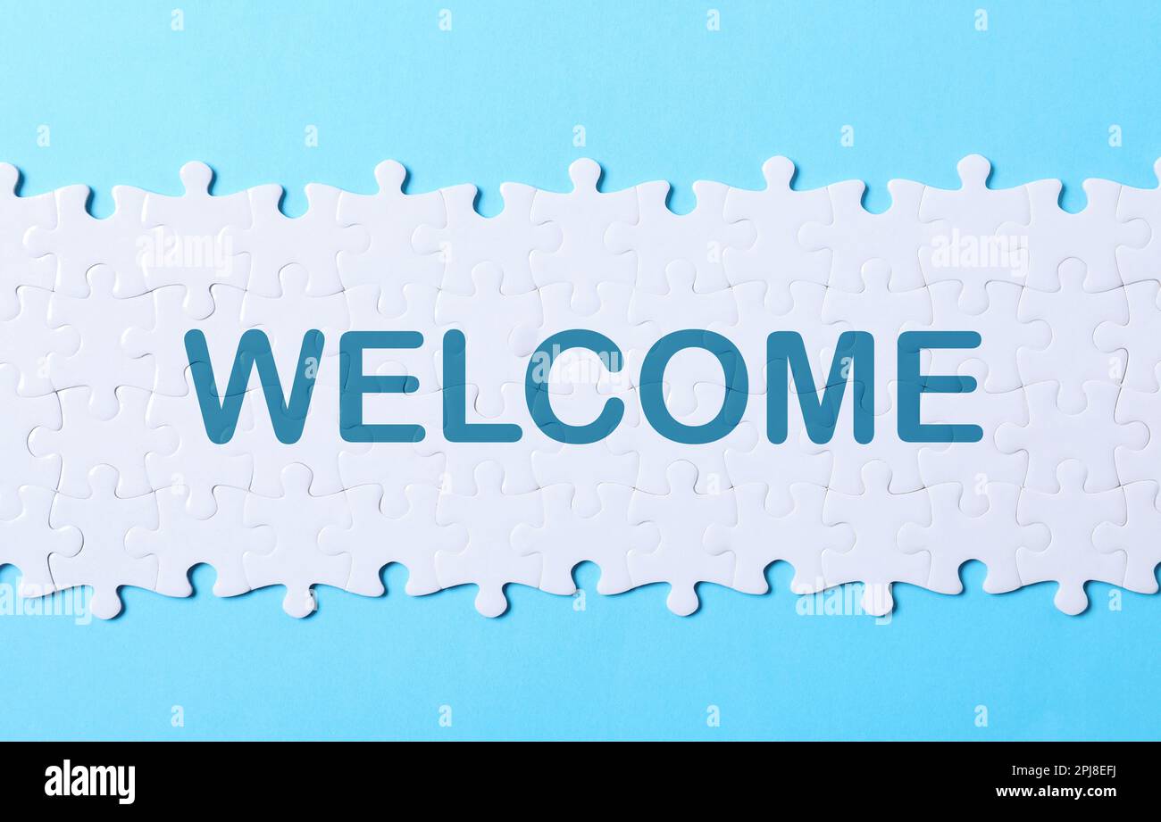 White puzzle pieces and word WELCOME on light blue background, top view ...