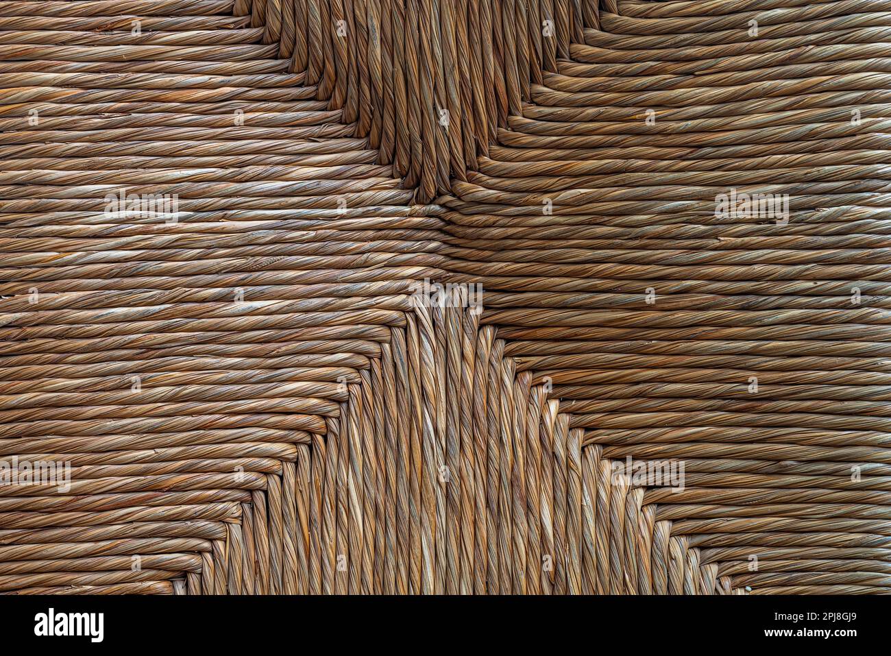 Geometric texture of brown and yellow colored straw chair, usable as a ...