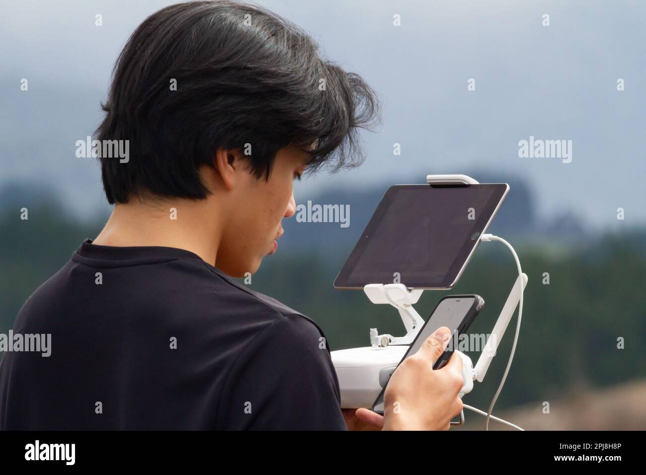 Drone remote control operation while using a phone Stock Photo - Alamy