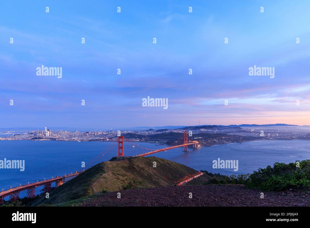 Red suspension bridge across Golden Gate to San Francisco after sunset ...