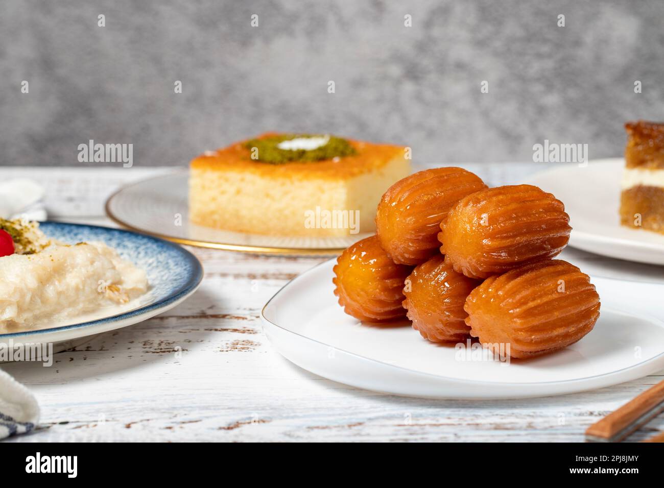 Güllaç, revani, tulumba and bread kadayif dessert with cream on a wood ...