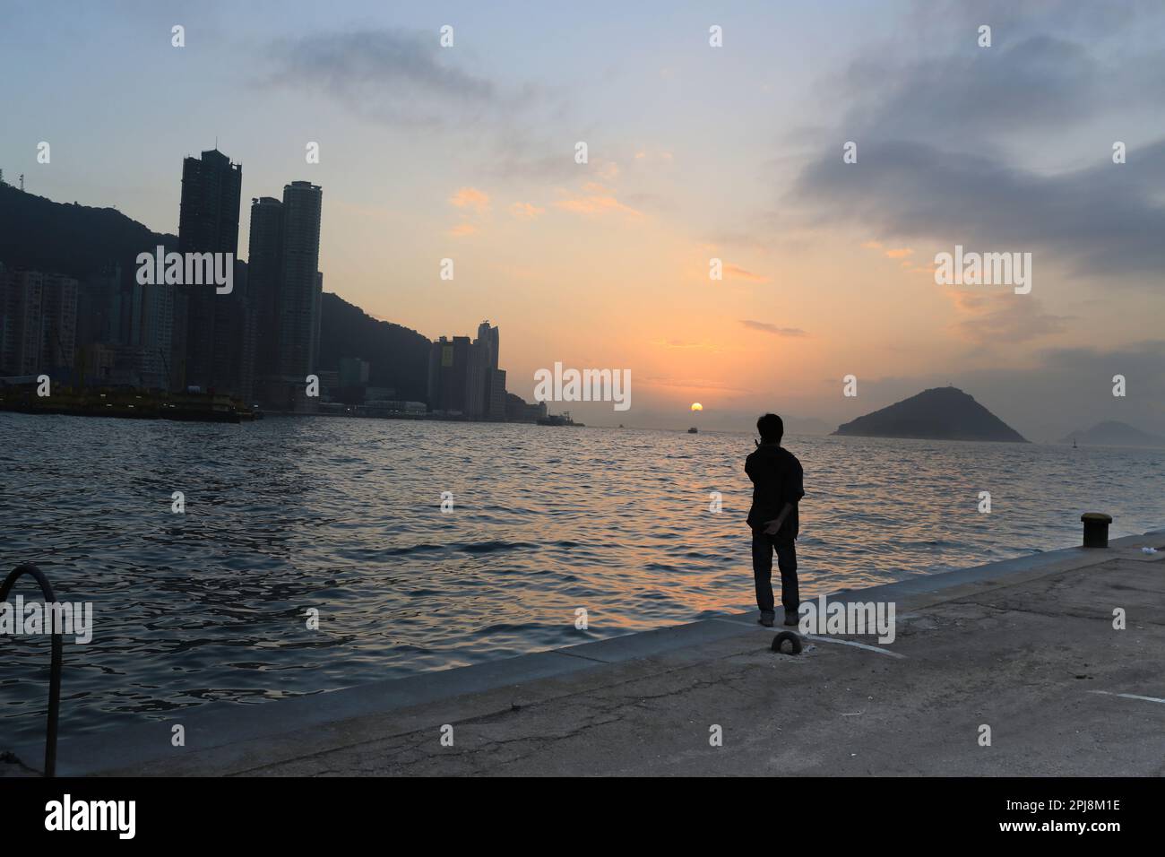 Man watching the far away sunset deep thinking in the pier waiting ...