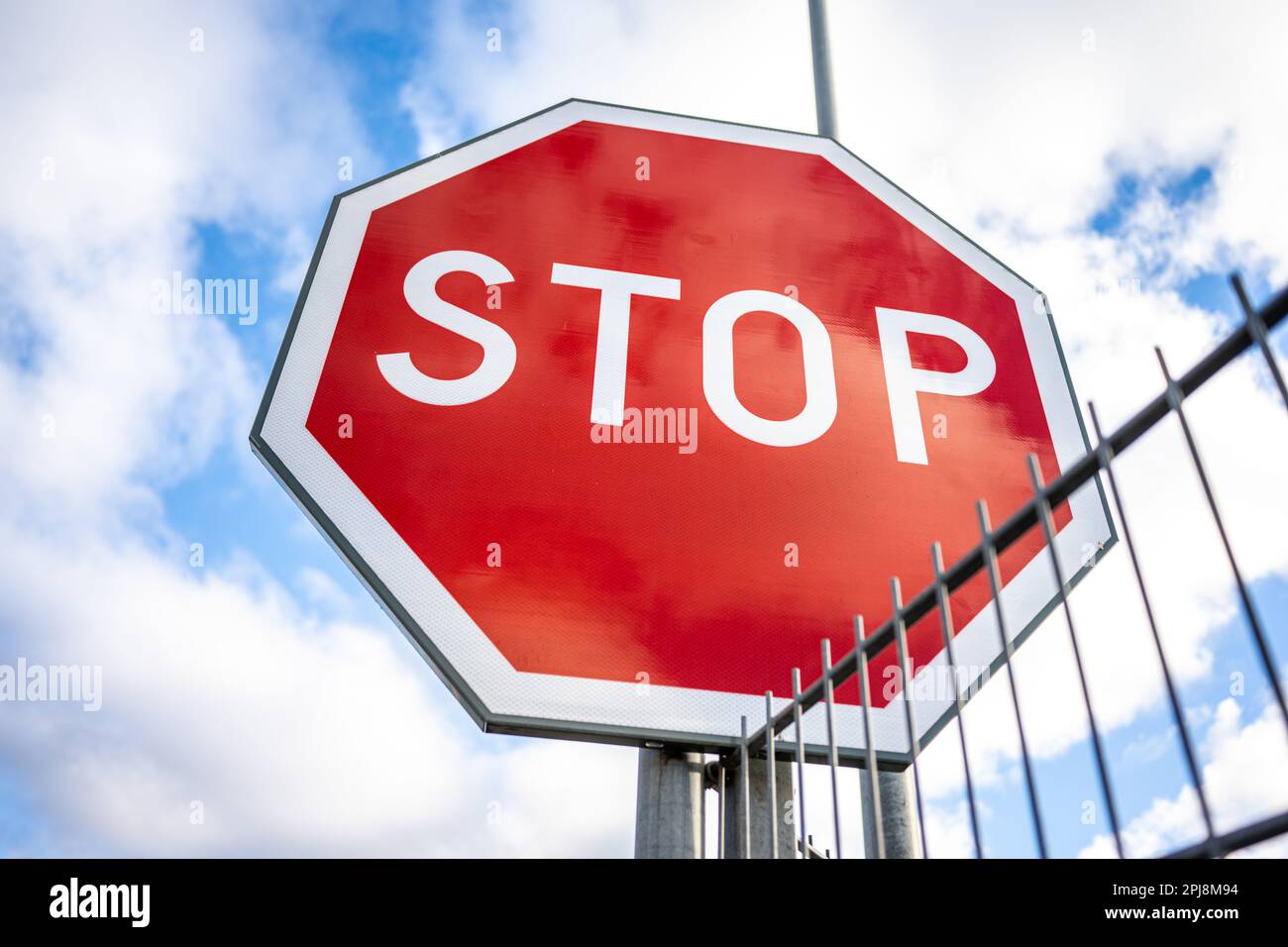Closeup photo of a stop sign by a fence Stock Photo - Alamy