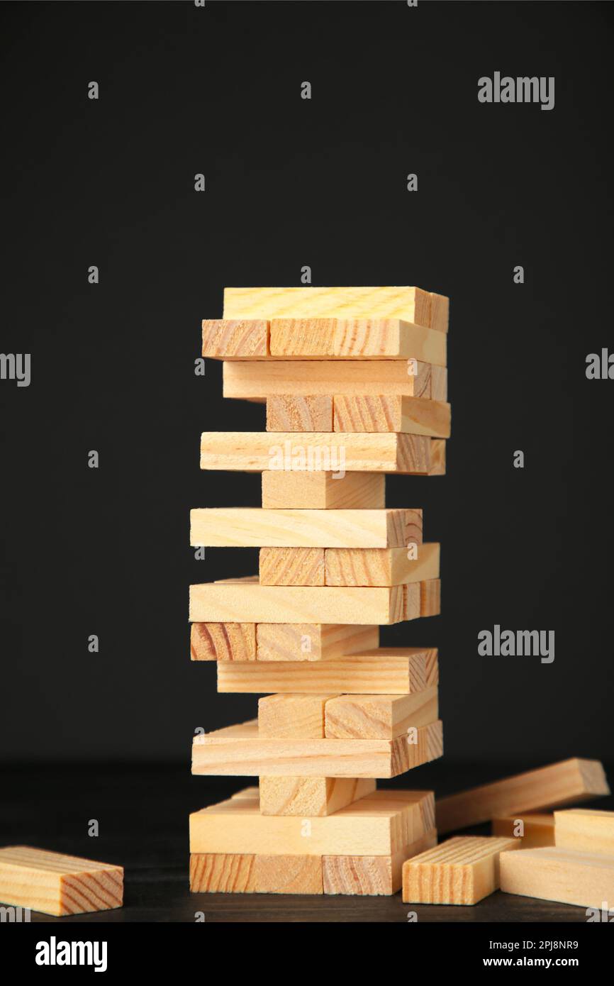Business risk concept with wood jenga game. Wooden blocks on black ...