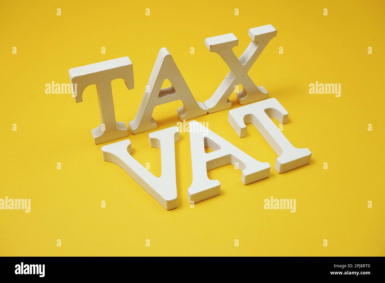 Tax Vat alphabet letters on yellow background Stock Photo - Alamy
