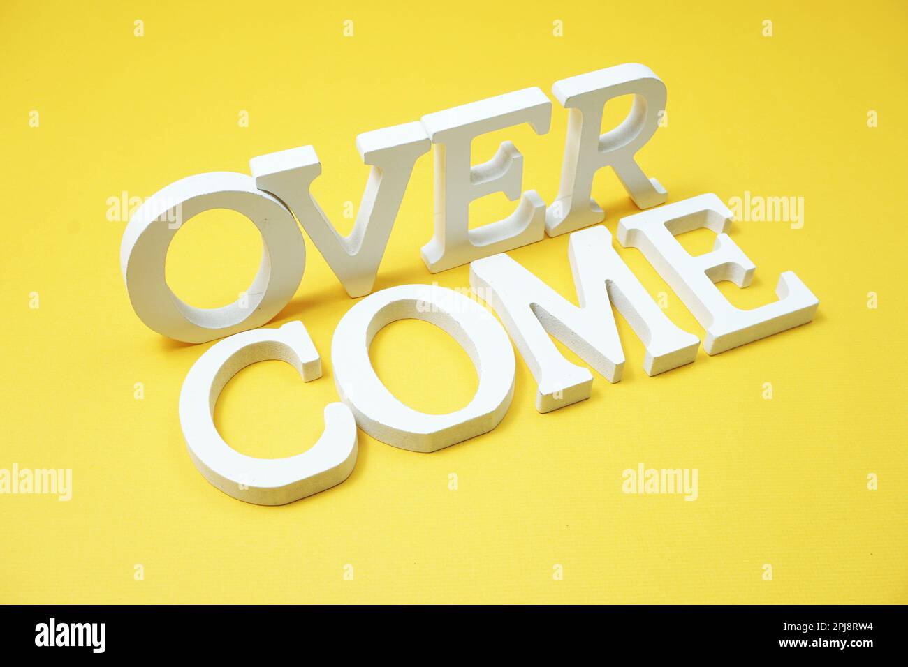 Over Come alphabet letters on yellow background Stock Photo - Alamy