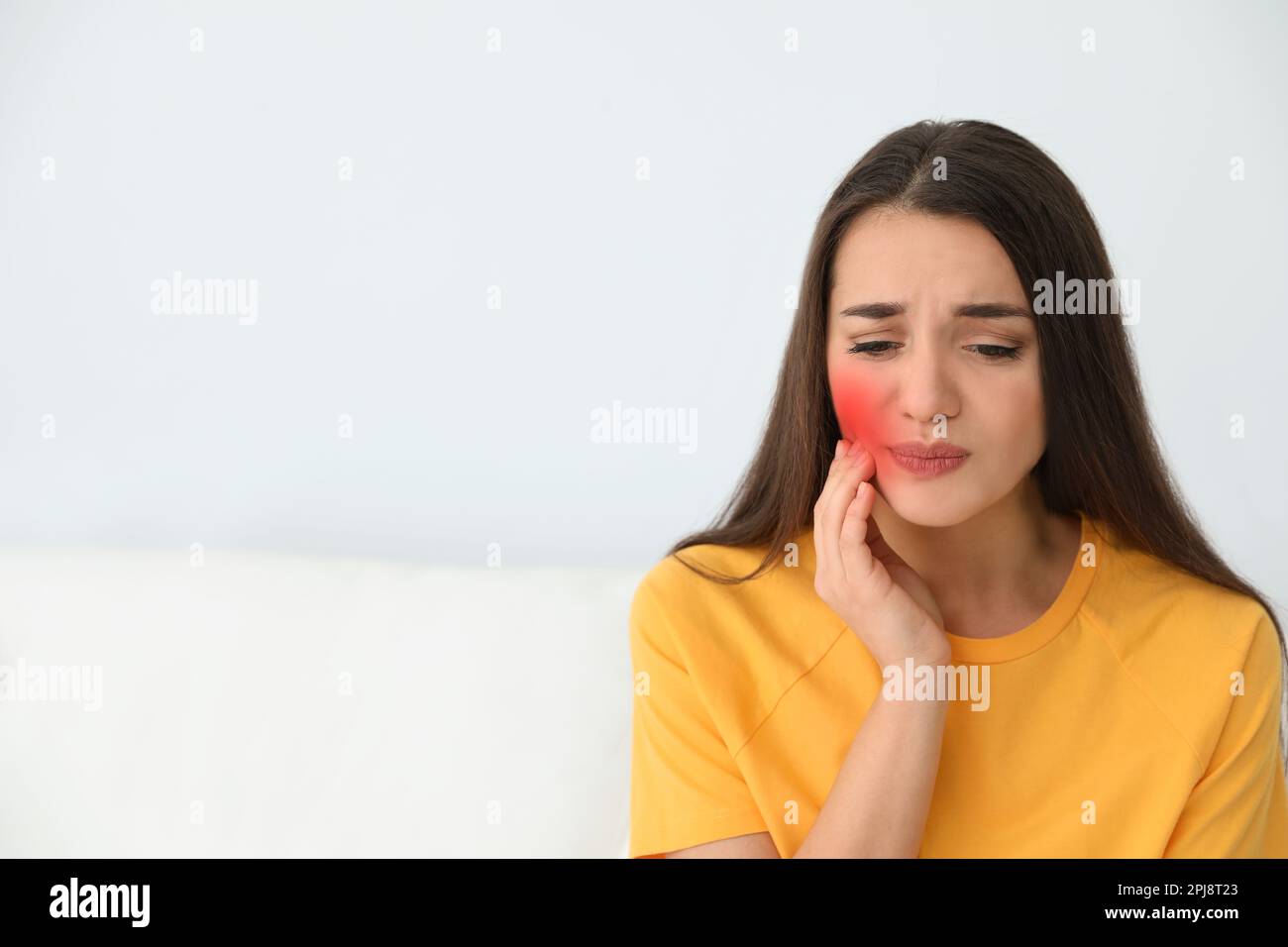 Young woman suffering from acute toothache on white background , space ...
