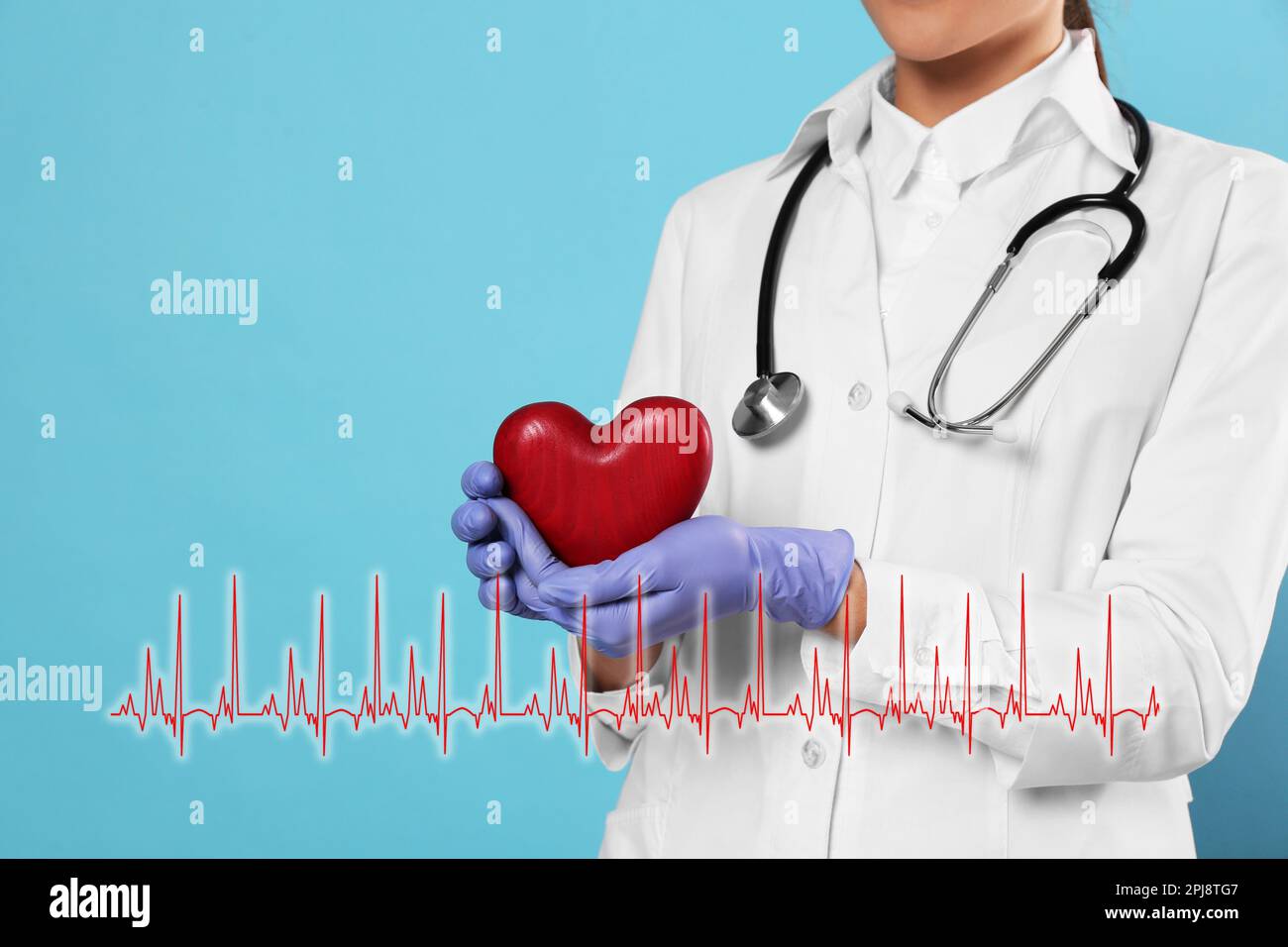 Closeup view of doctor with stethoscope holding red heart and ...