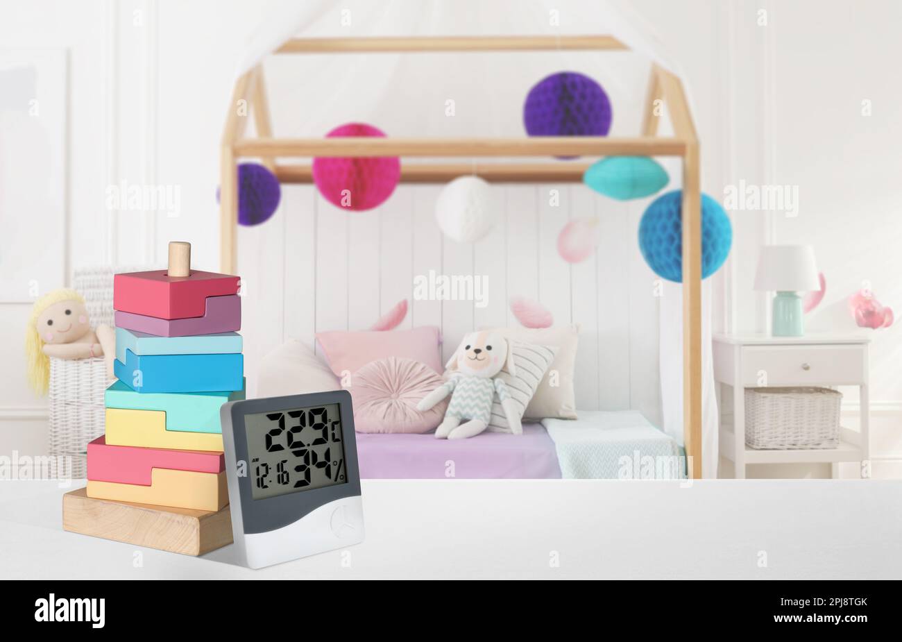 Digital hygrometer with thermometer on white table in children's room ...
