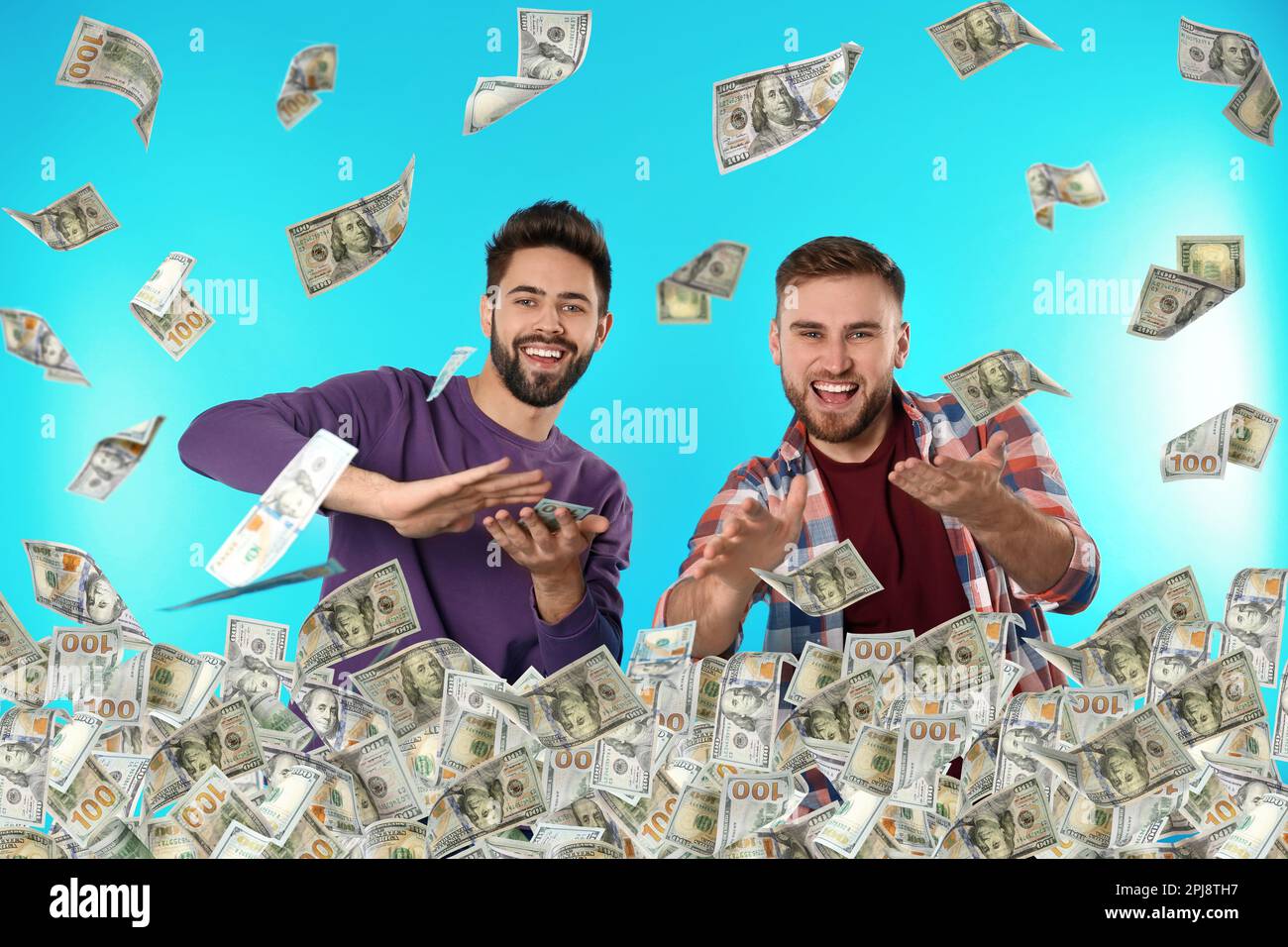 Happy young men with money and falling American dollars on turquoise ...