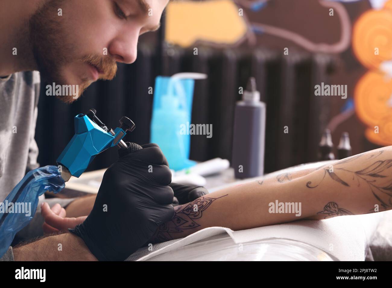 Professional artist making tattoo in hi-res stock photography and ...