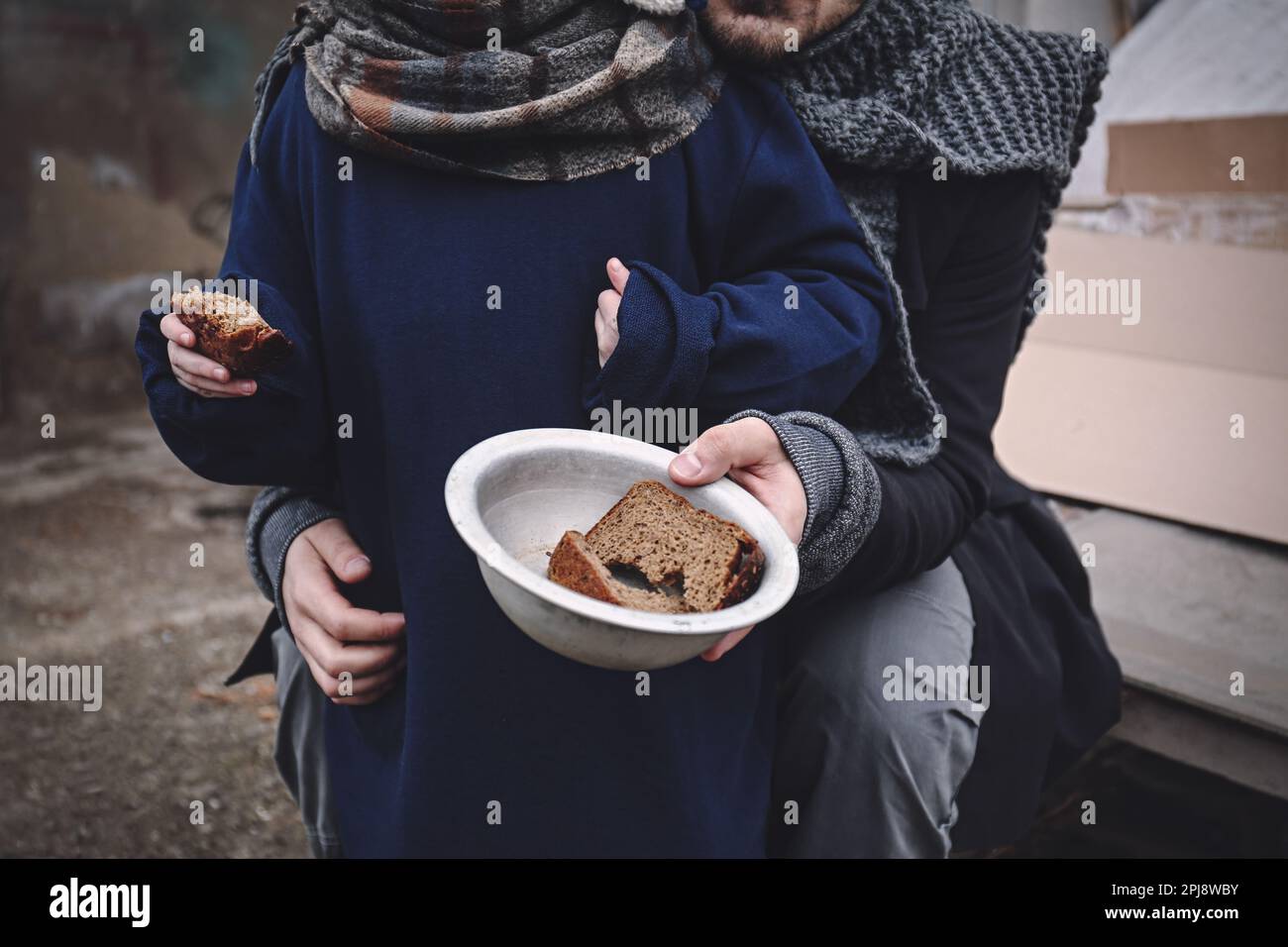 Poor father and child with bread at dump, closeup Stock Photo - Alamy