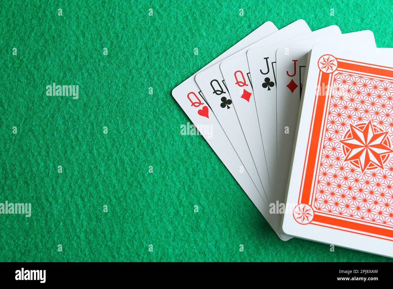 Playing cards with full house combination on green table, top view ...
