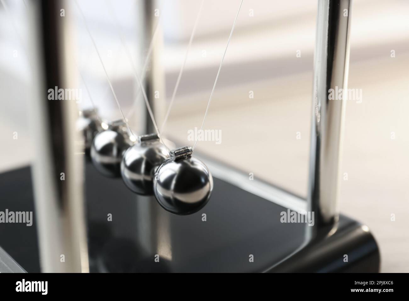Newton's cradle on table, closeup. Physics law of energy conservation ...