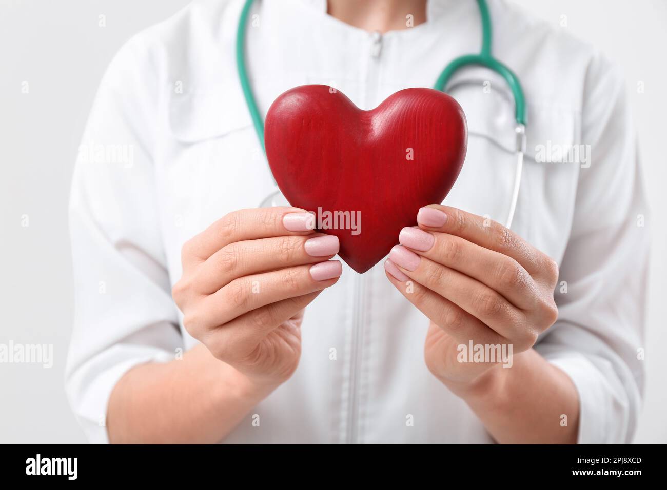 Doctor holding red heart on white background, closeup. Cardiology ...