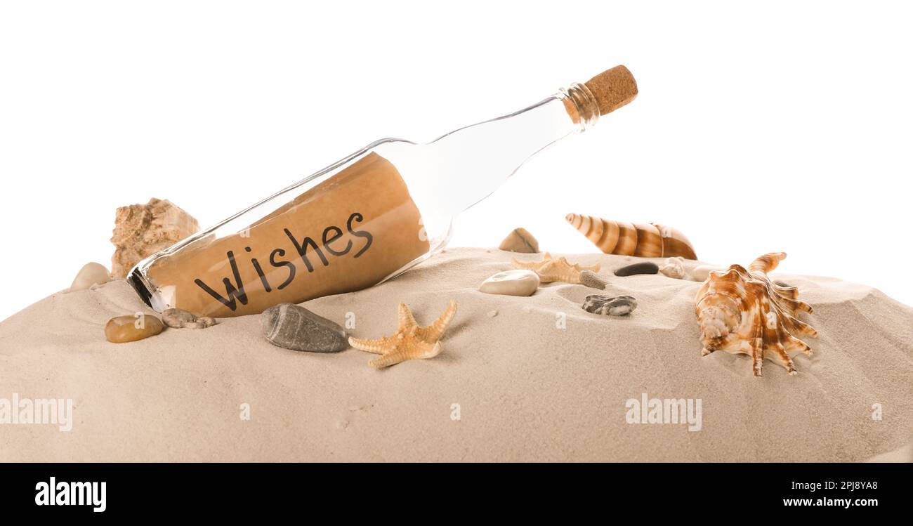 Corked glass bottle with Wishes note and seashells on sand against ...