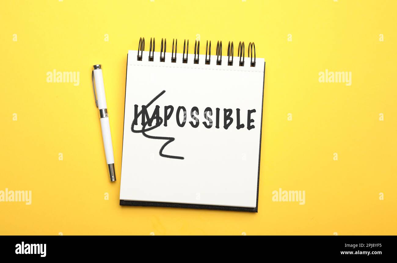 Word IMPOSSIBLE with crossed out letters IM written in notebook and ...