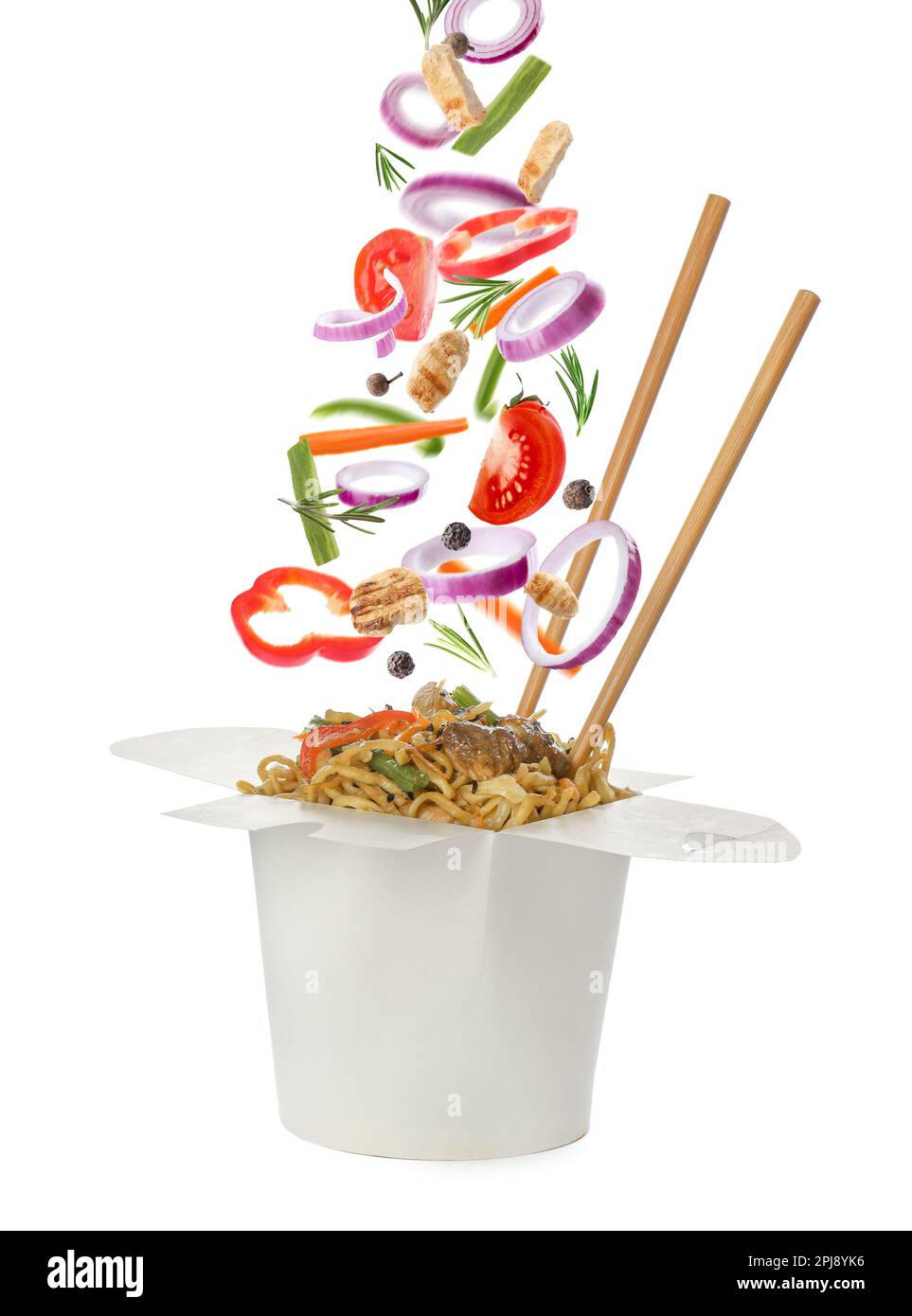 DIfferent fresh ingredients falling into box of wok noodles on white ...