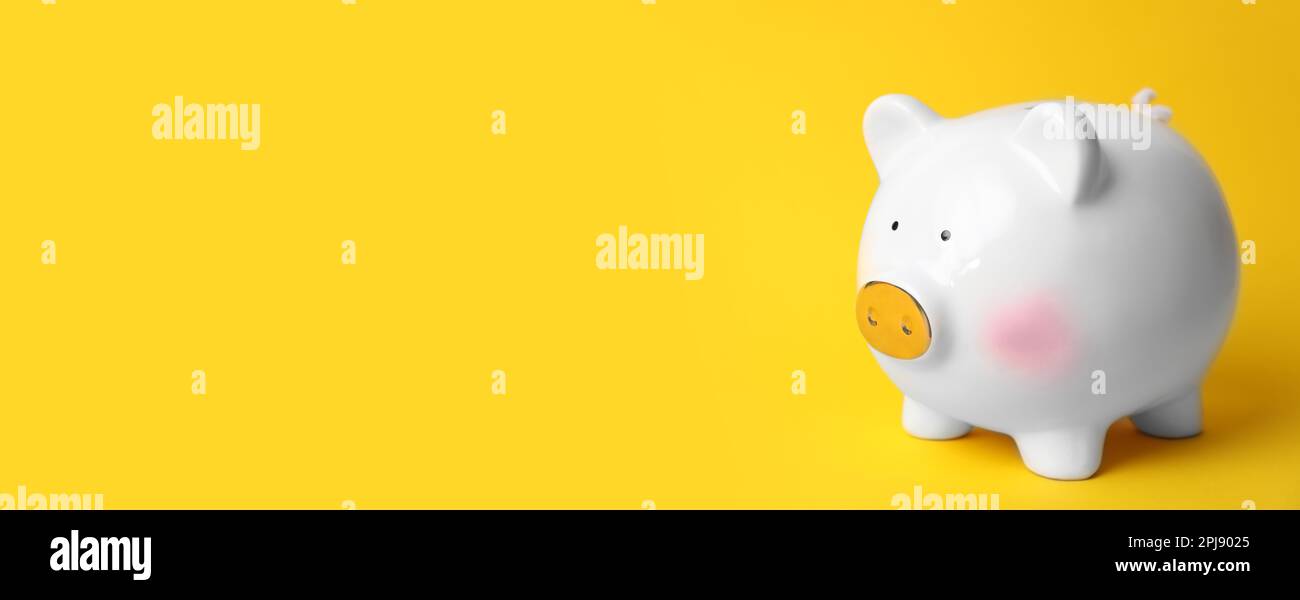 White piggy bank on yellow background, space for text. Banner design ...
