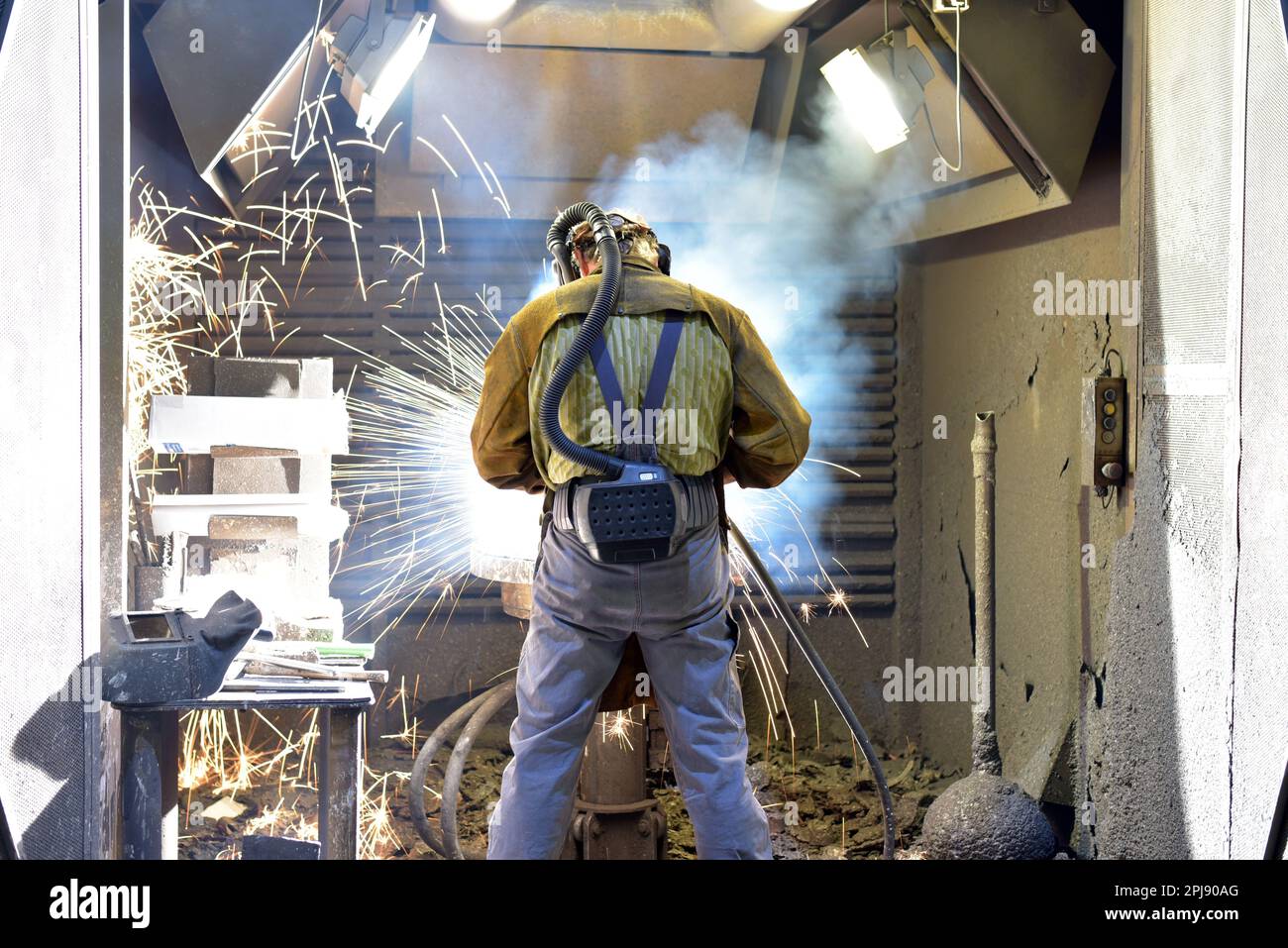 Welder in protective clothing at the workplace in an industrial company ...