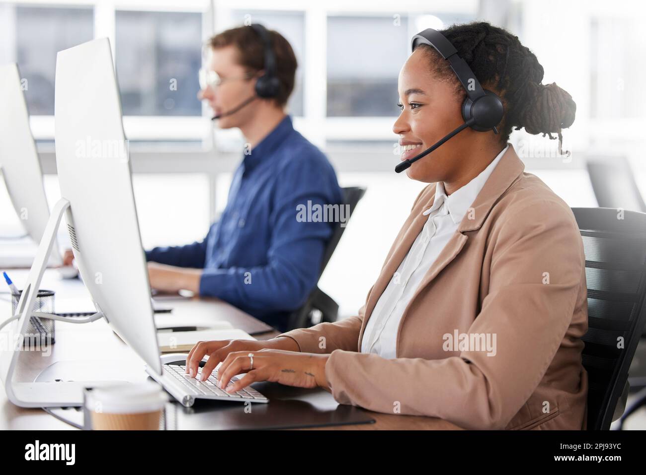 Black woman, call center and typing on computer, smile in office and ...