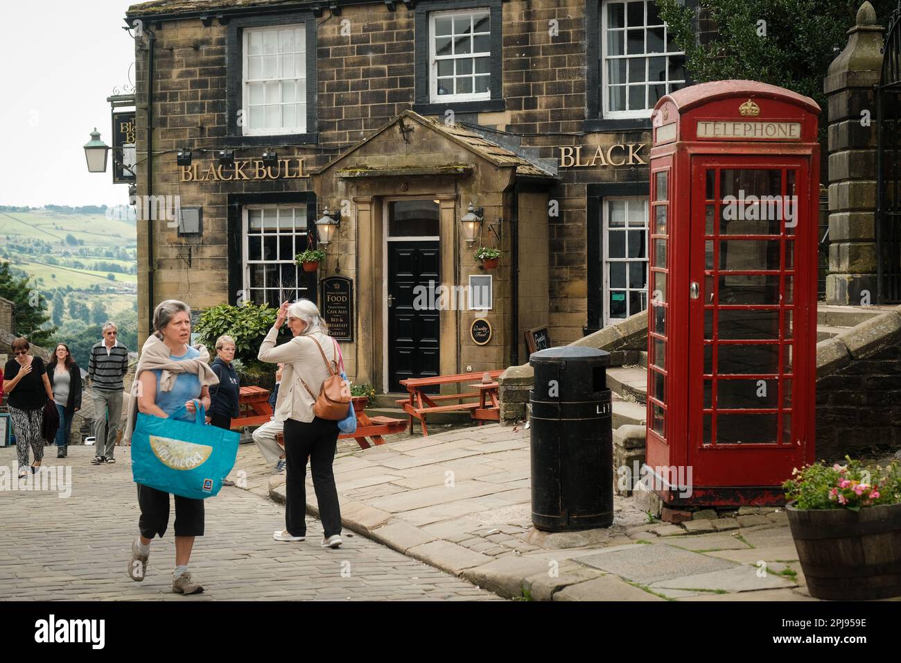 Haworth, West Yorkshire, UK. A red Telephone Box and The Black Bull at ...