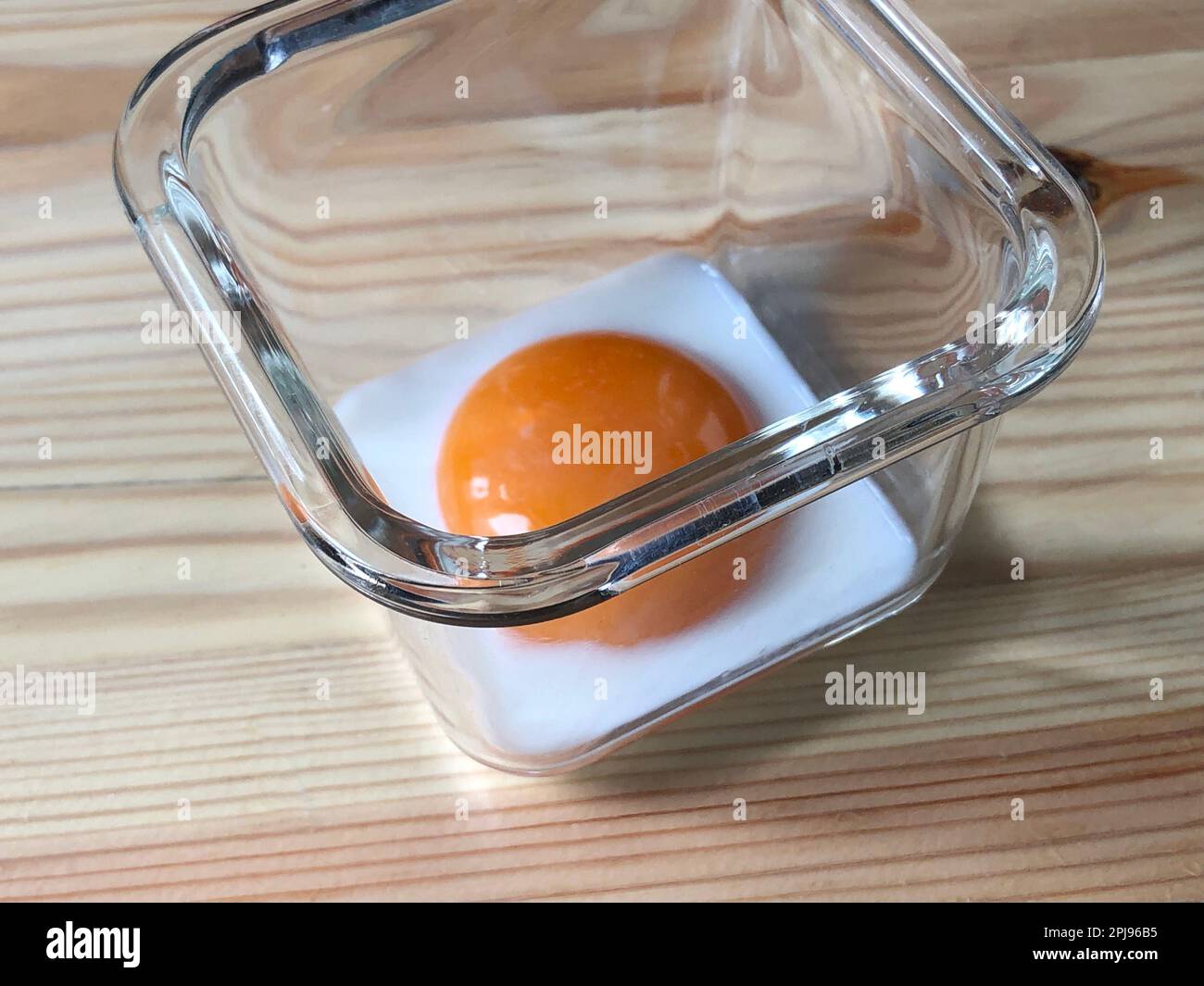 Raw eggs, top view, broken egg, yolk protein in a square dish Stock ...
