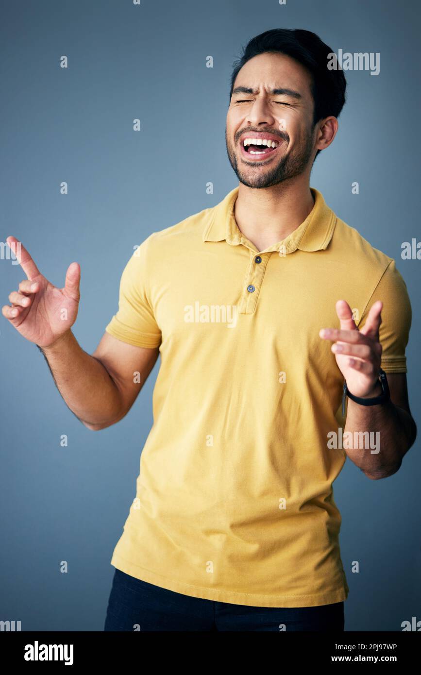 Karaoke, happy and a singing Asian man with a song isolated on a grey ...