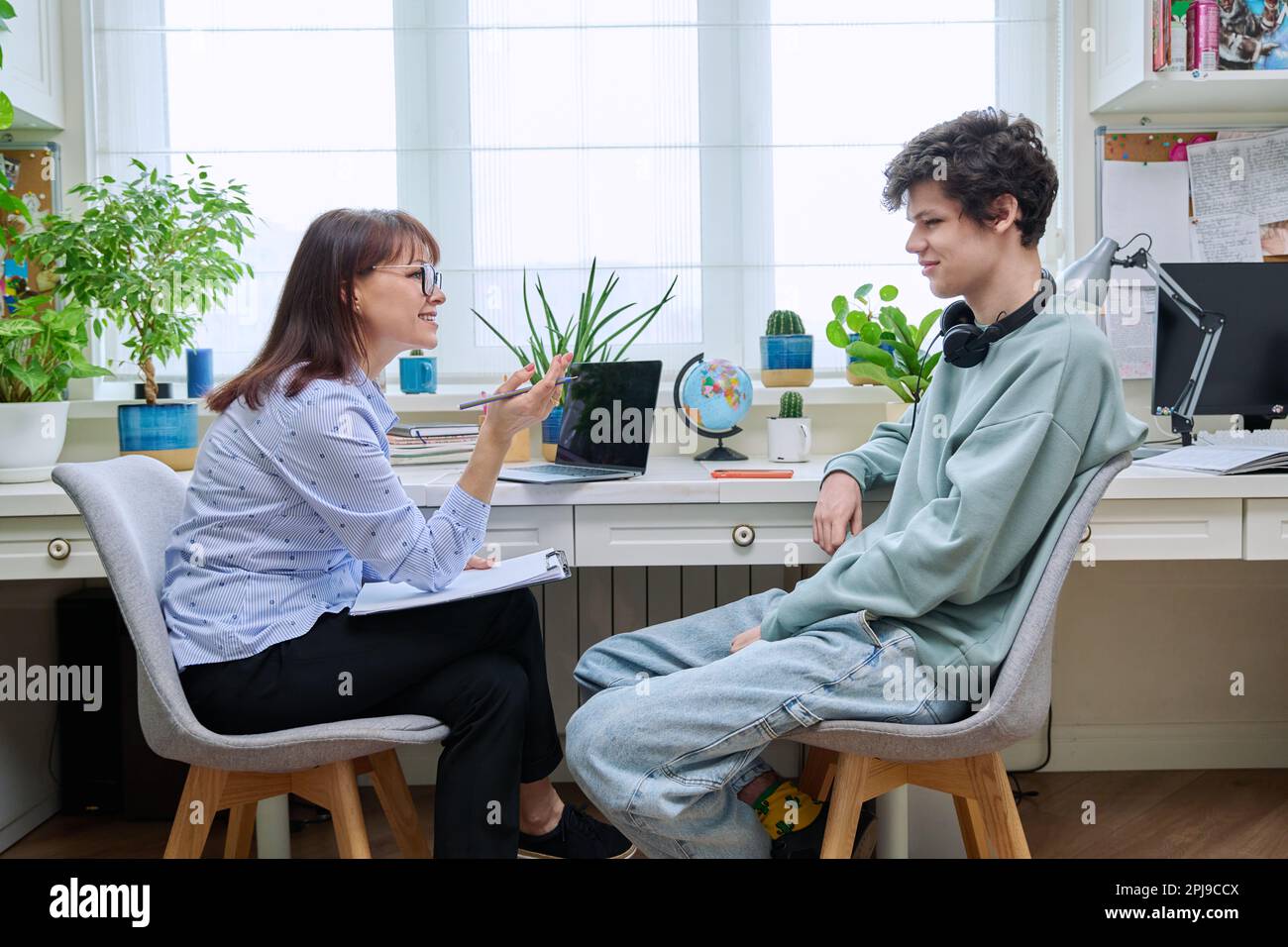 Positive friendly female psychologist talking to young guy Stock Photo ...