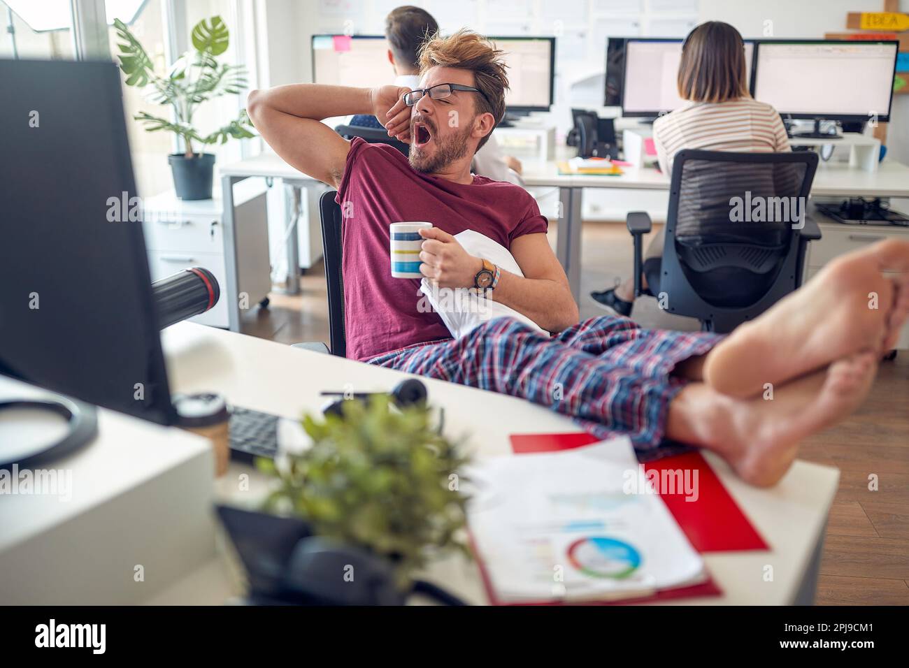 Overworked caucasian male trying to stay awake in the office Stock ...