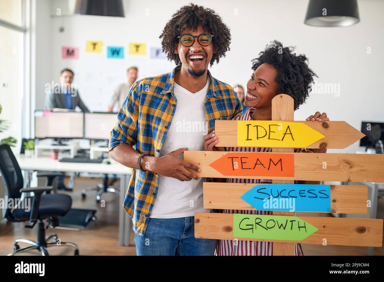 Young cheerful colleagues are enjoying posing for a photo while ...