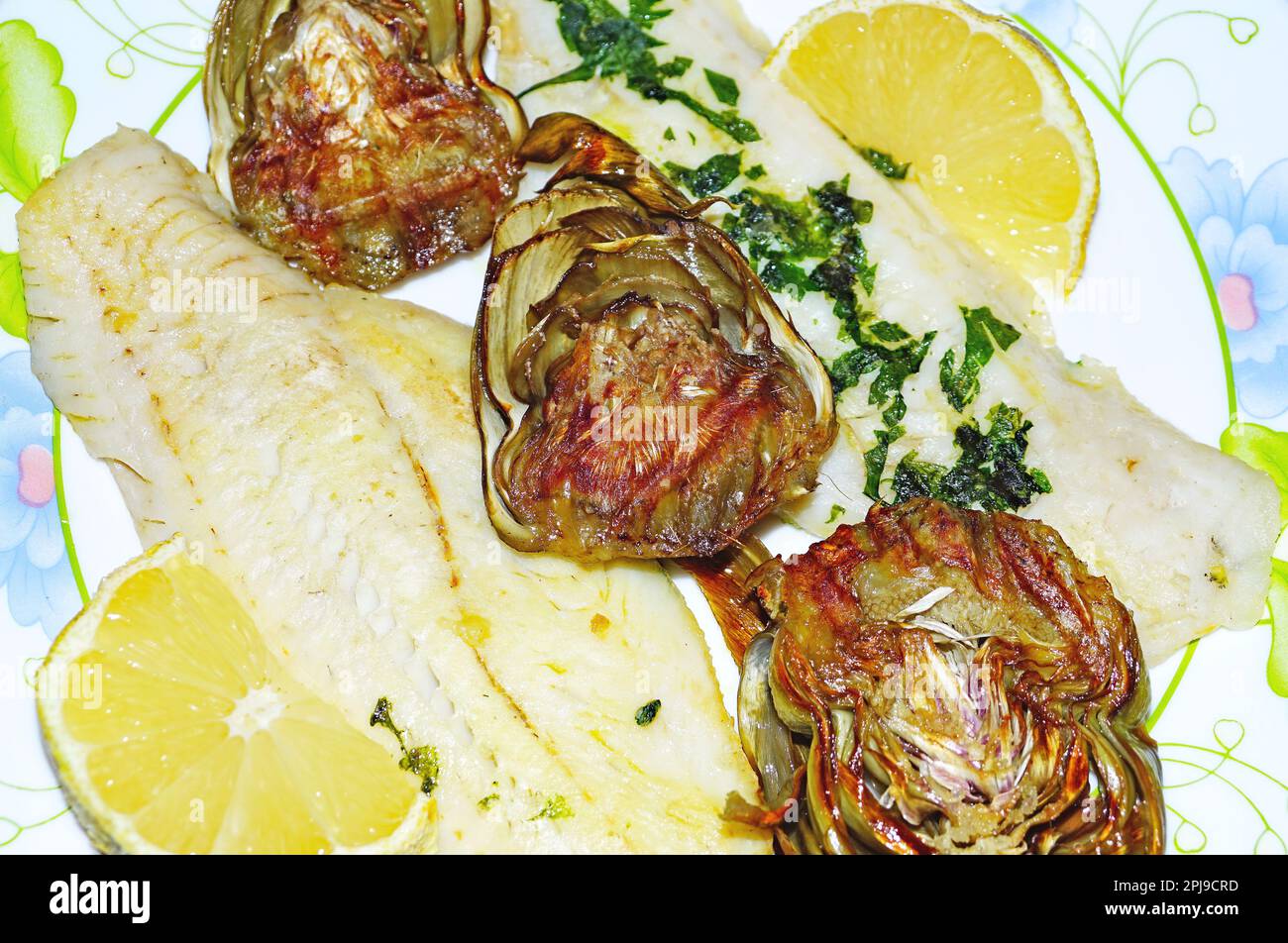 Combo plate of hake fillet with grilled artichoke Stock Photo - Alamy