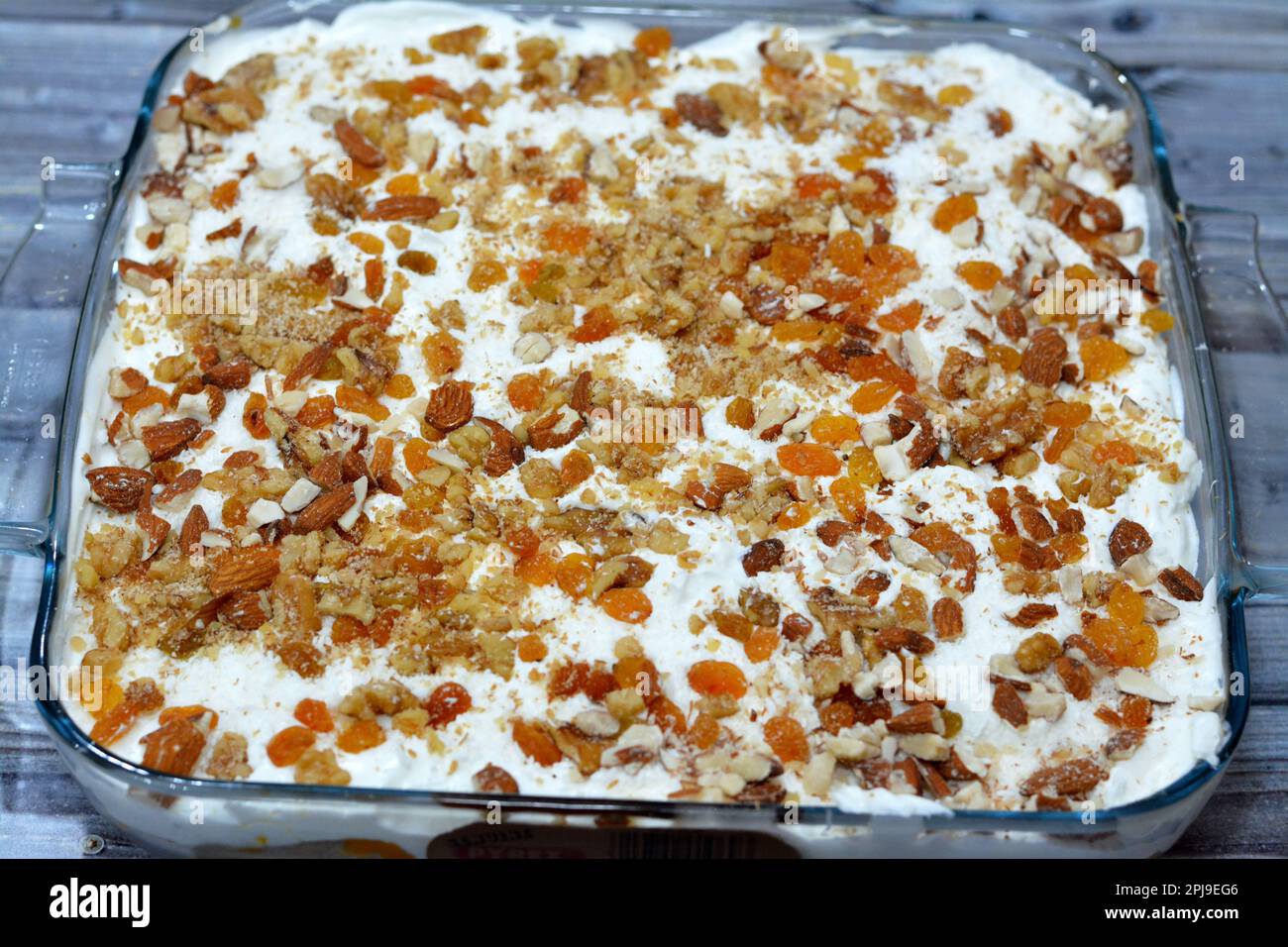 Konafa topped with whipped cream, raisins, nuts, shredded coconut and ...