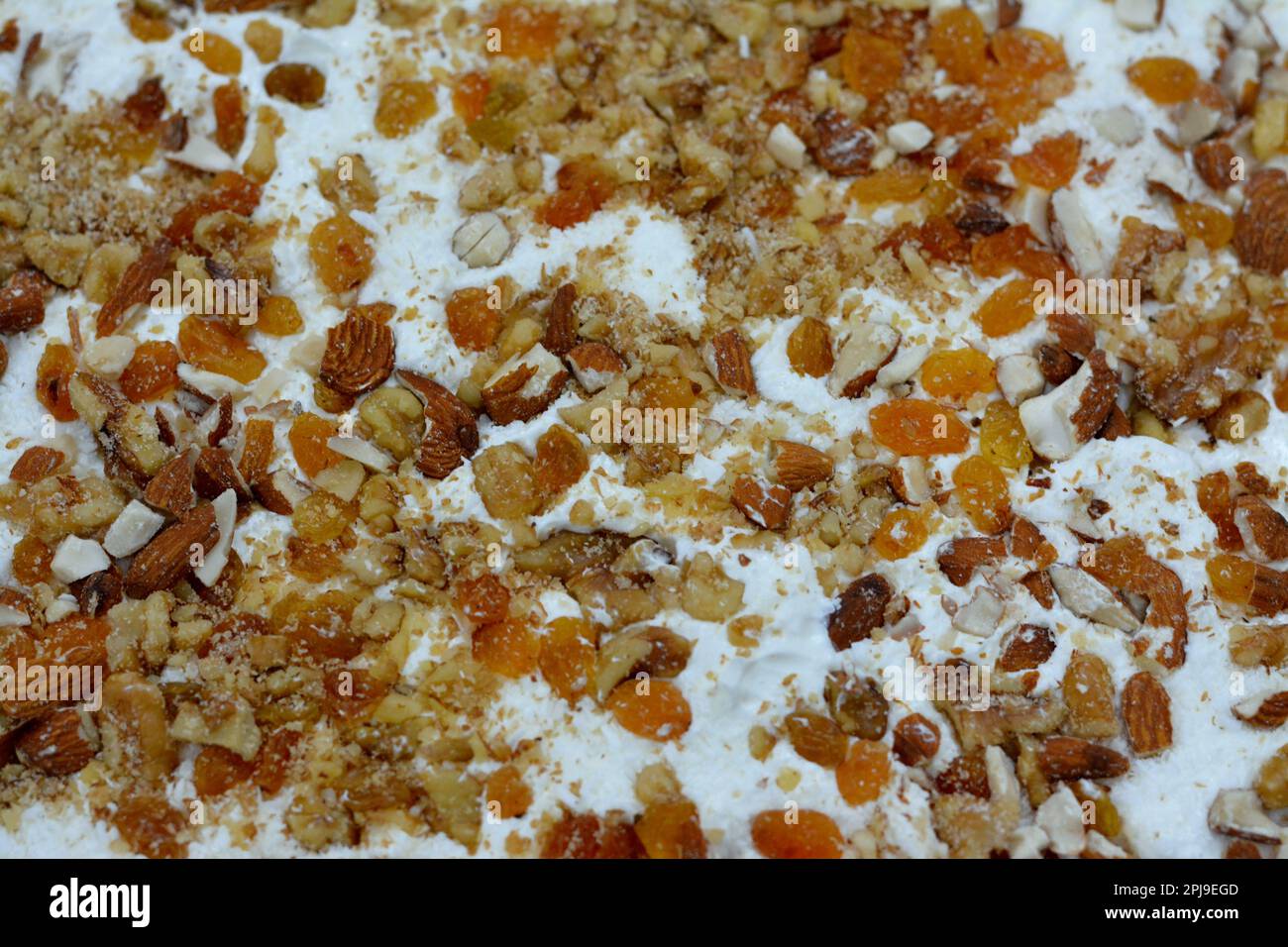 Konafa topped with whipped cream, raisins, nuts, shredded coconut and ...