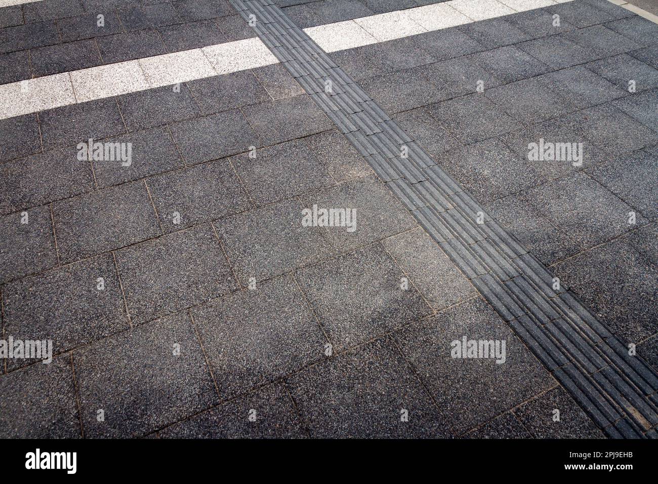 Textured walkway for blind people. Black tactile paving for the ...