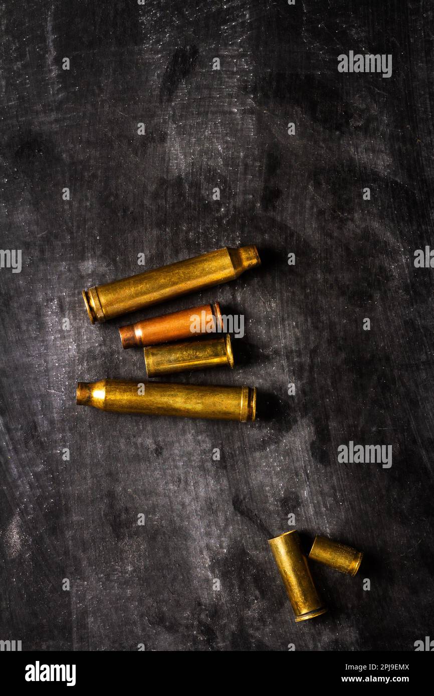 Empty bullet cartridges lying on the black background Stock Photo - Alamy