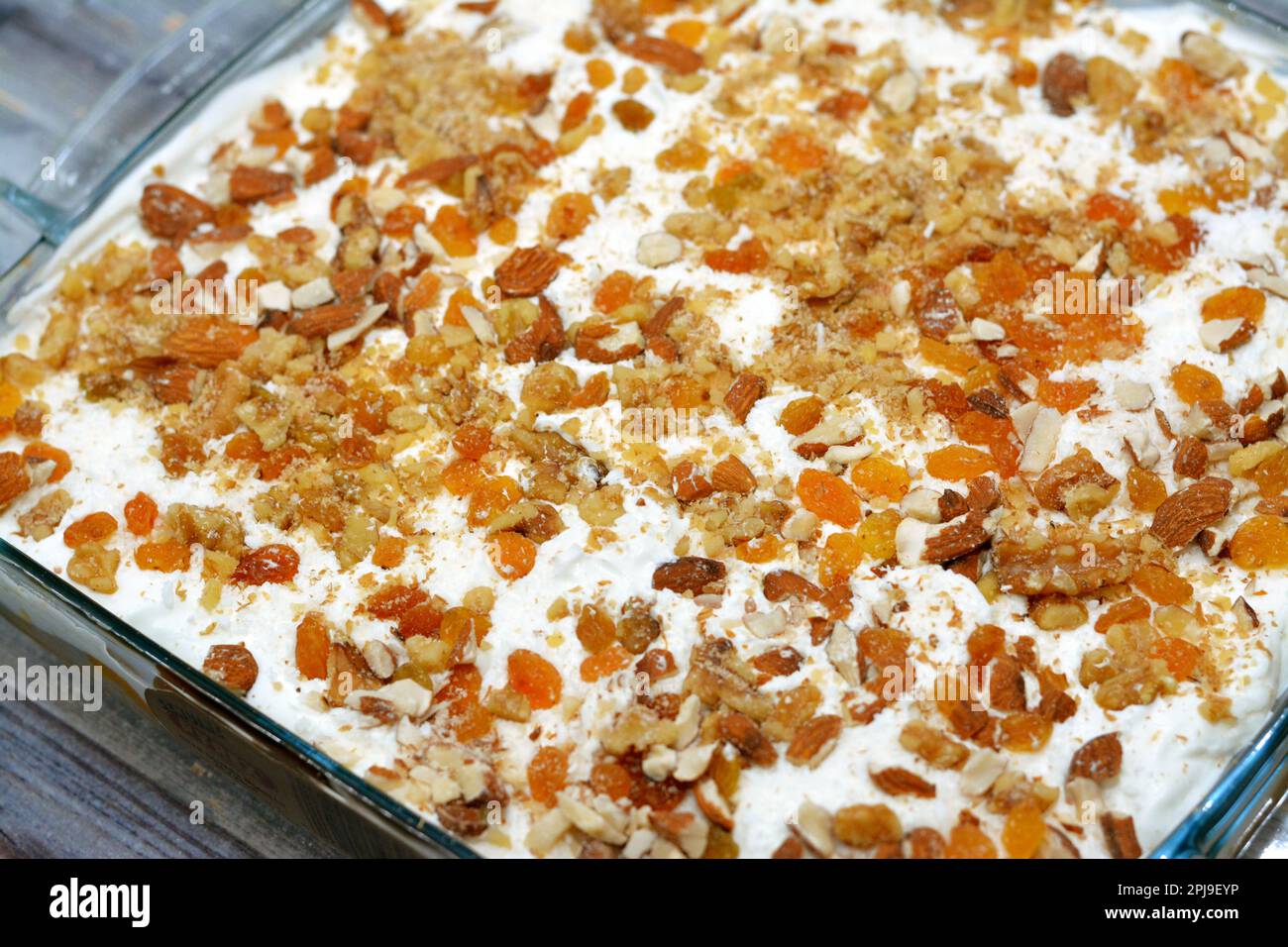 Konafa topped with whipped cream, raisins, nuts, shredded coconut and ...