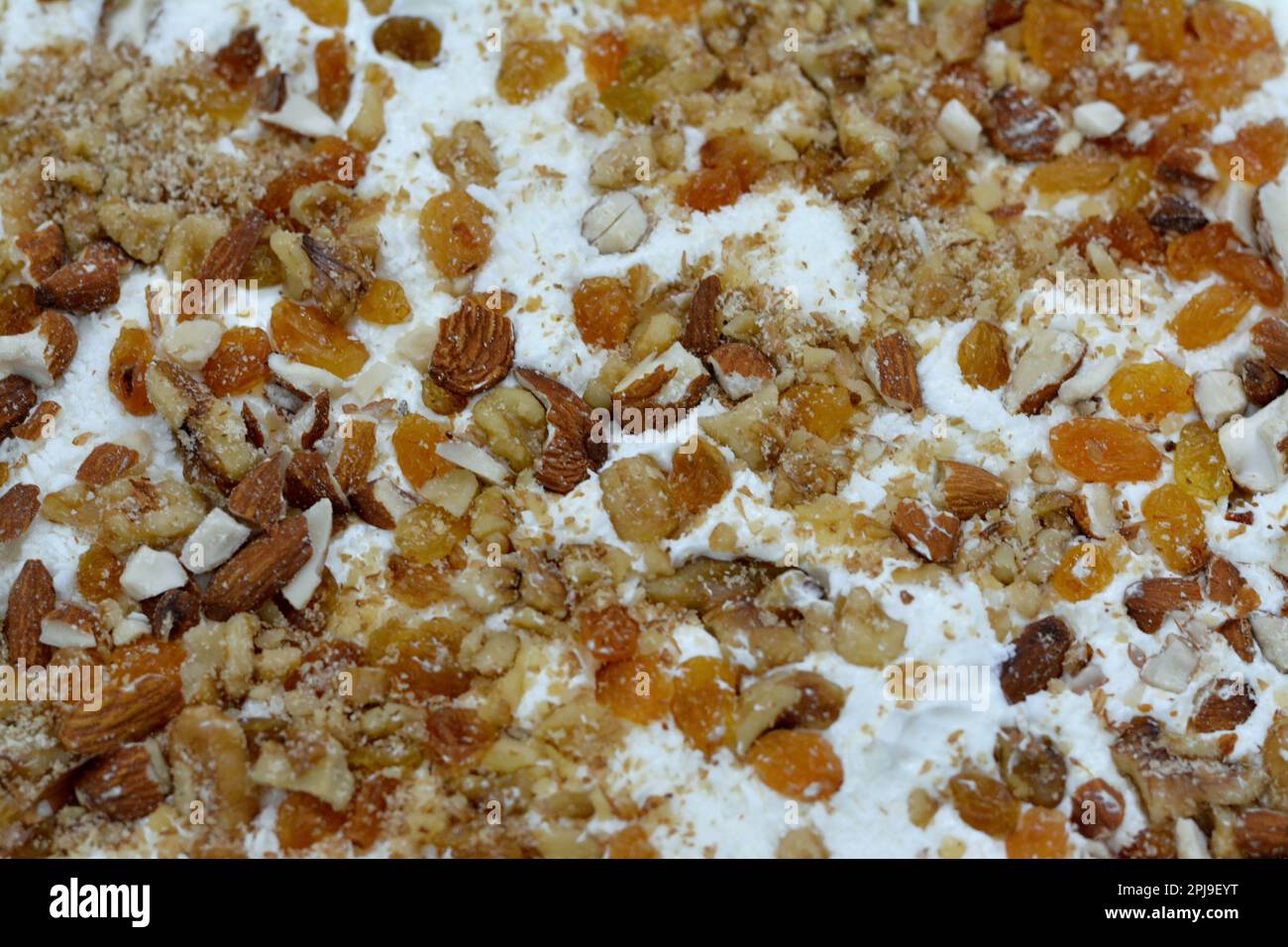 Konafa topped with whipped cream, raisins, nuts, shredded coconut and ...