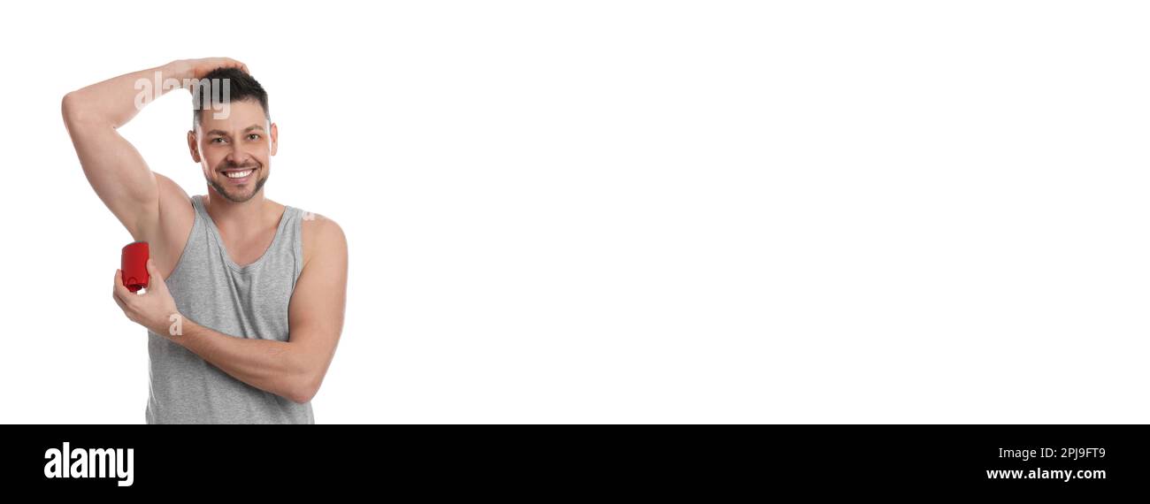 Handsome man applying deodorant on white background, space for text ...