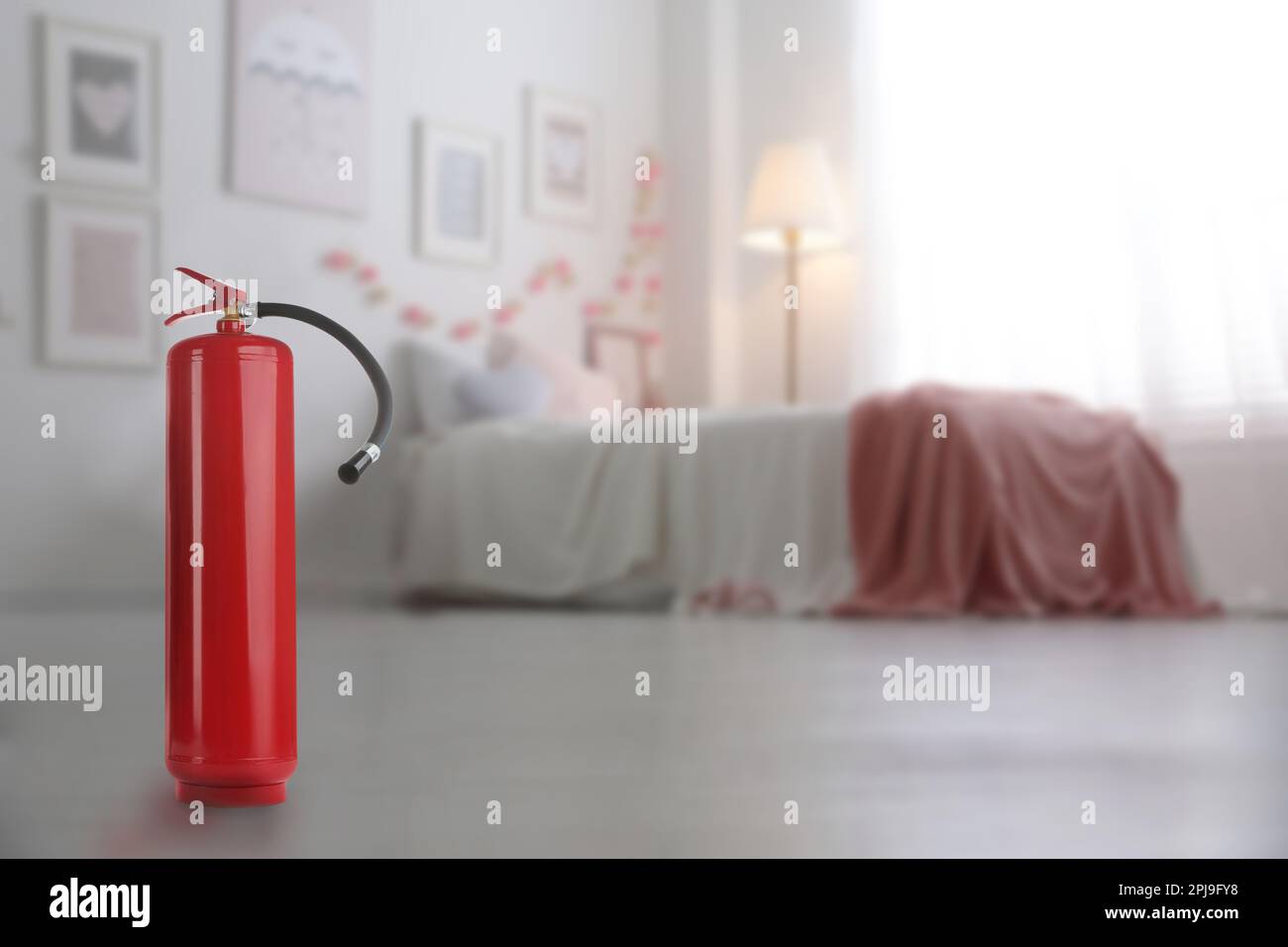 Fire extinguisher on floor in bedroom. Space for text Stock Photo - Alamy