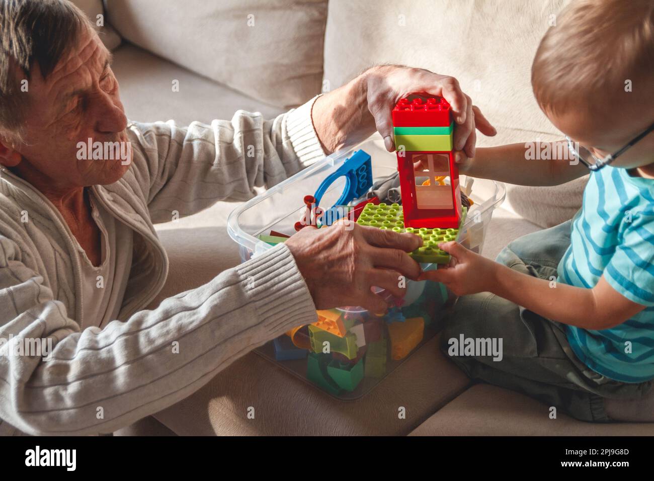 Elderly grandpa or grandfather plays with his little grandson Stock ...
