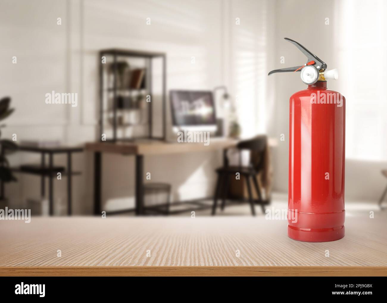 Fire extinguisher on wooden table in office. Space for text Stock Photo ...