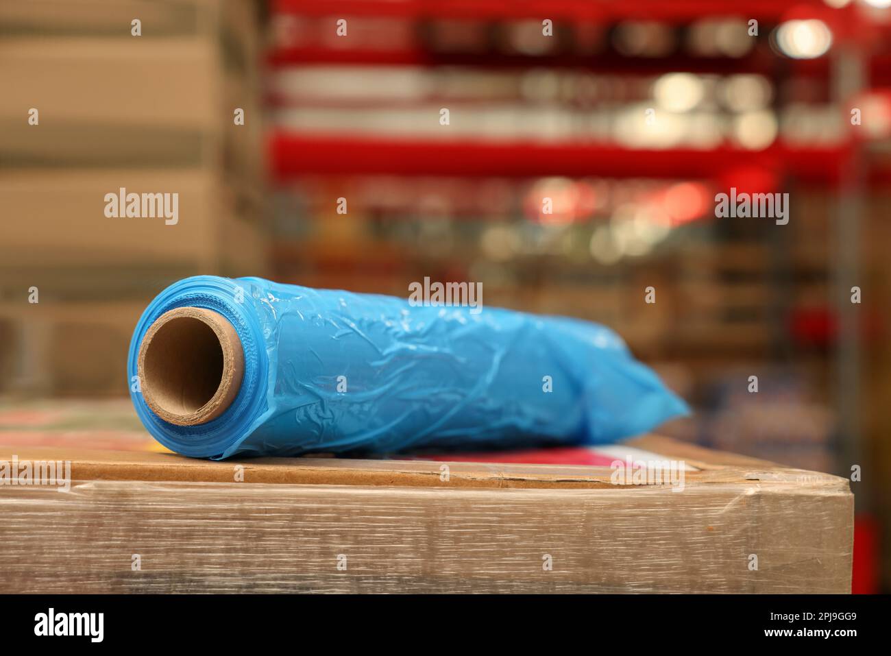 Roll of stretch wrap on box in warehouse Stock Photo - Alamy