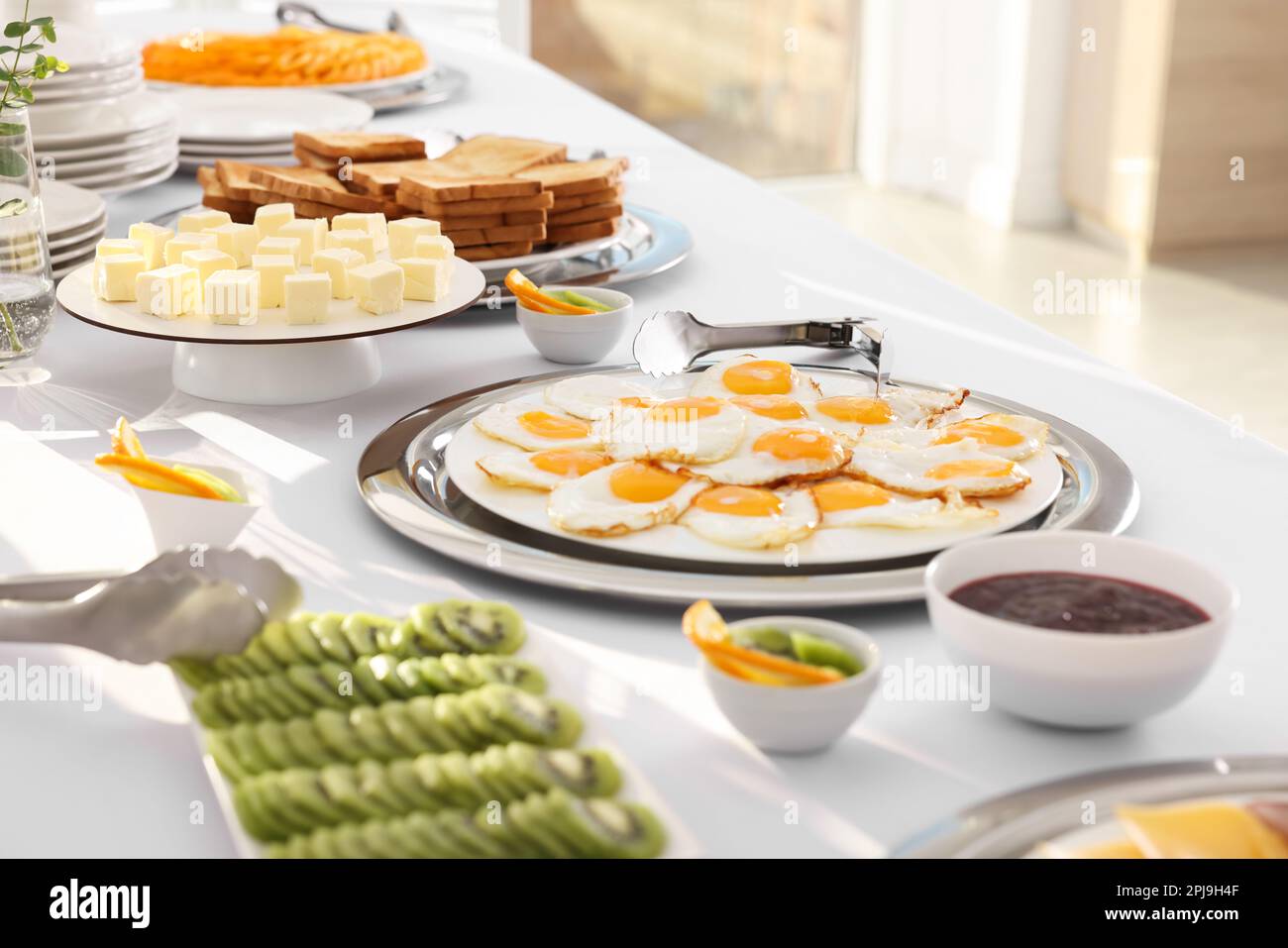 Different meals for breakfast on white table indoors. Buffet service ...