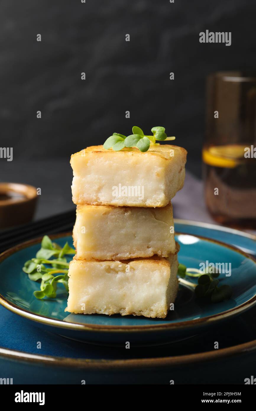 Delicious turnip cake with microgreens served on black table Stock ...